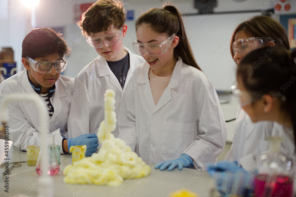 Surprised students conducting exploding foam scientific experiment in ...