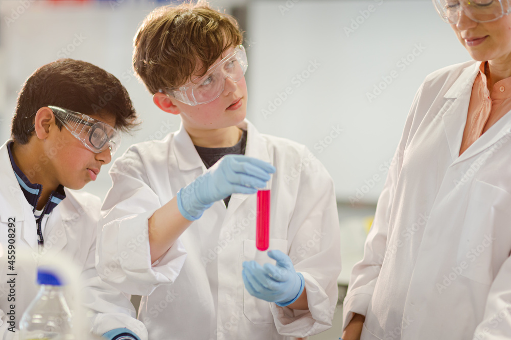 Boy students examining liquid in test tube, conducting scientific ...
