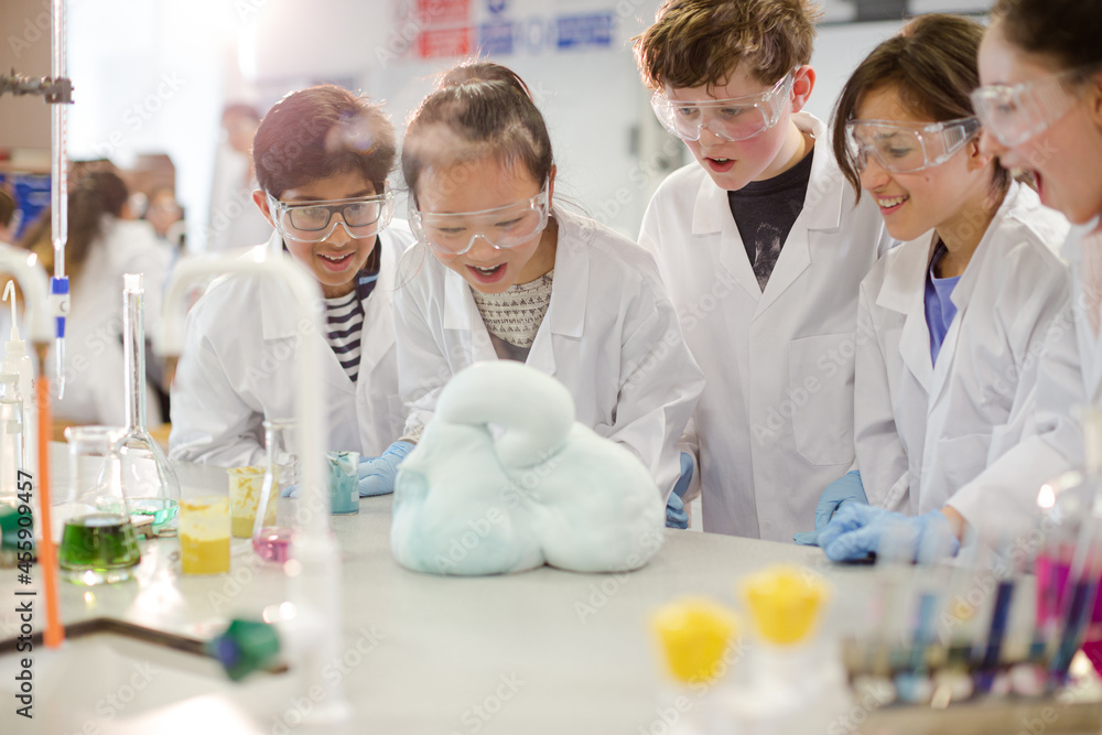 Surprised students conducting exploding foam scientific experiment in ...