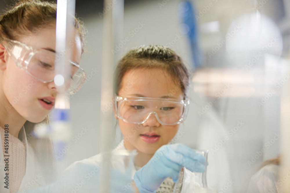 Girl student examining liquid in test tube, conducting scientific ...