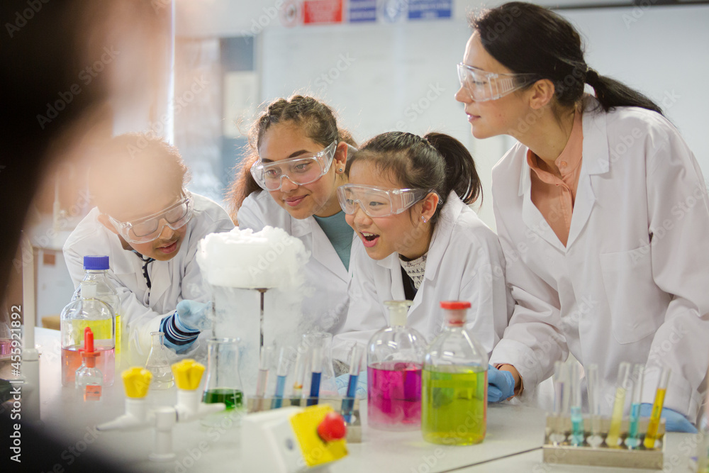 Surprised students conducting exploding foam scientific experiment in ...
