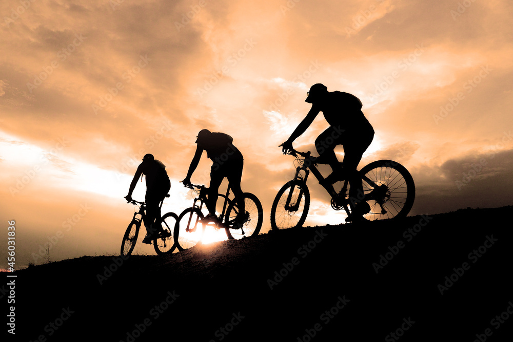 group of cyclists Cycling on a sandy beach with a sky background ...