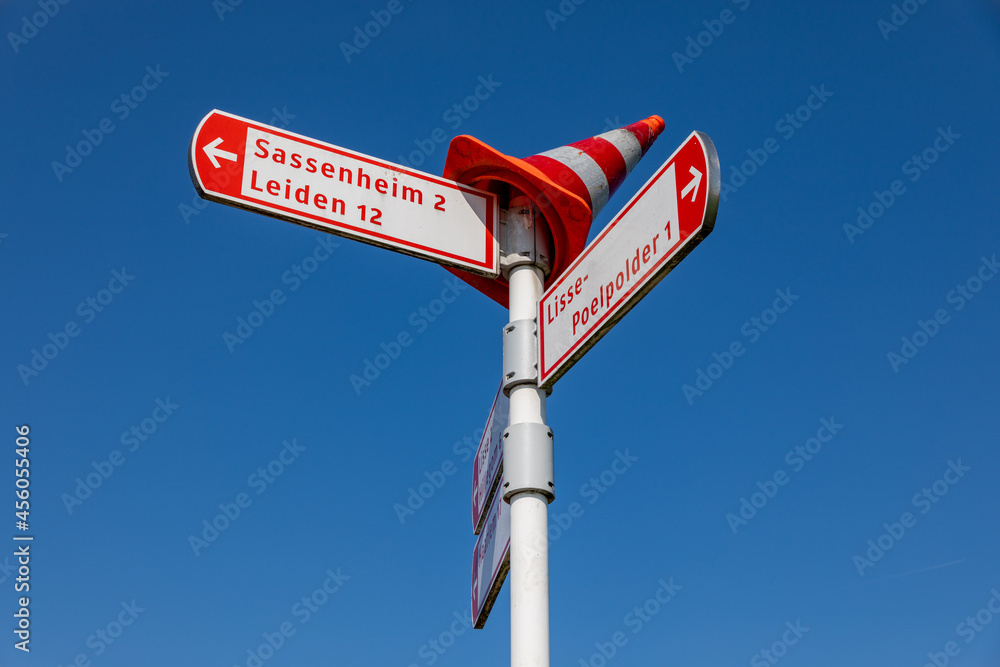 Dutch bike sign pole on crossroad with directions and distances in ...