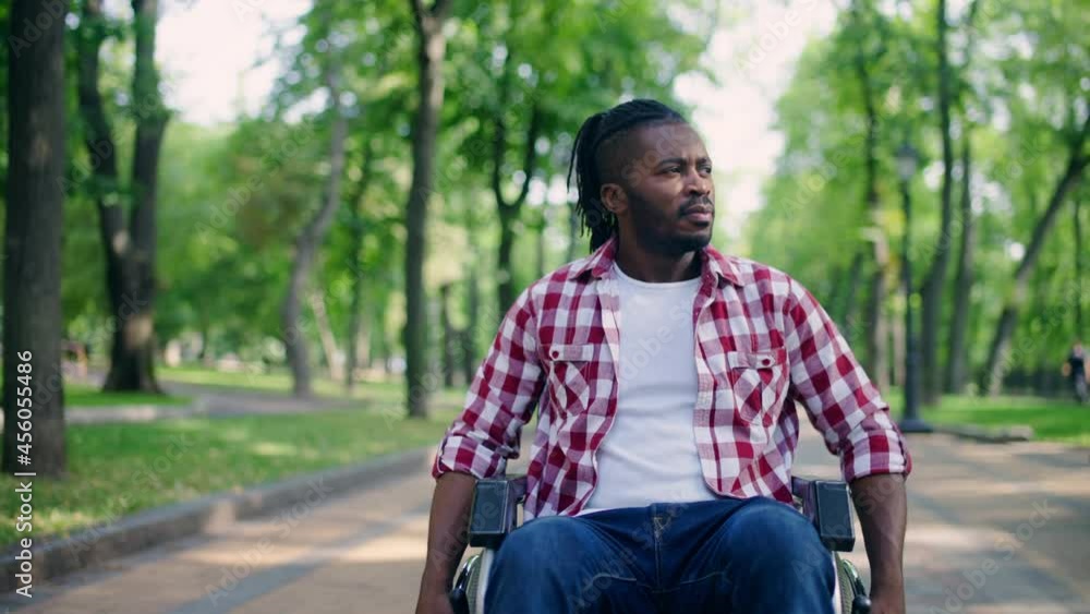 Positive black man with disability using wheelchair in park, hope for ...