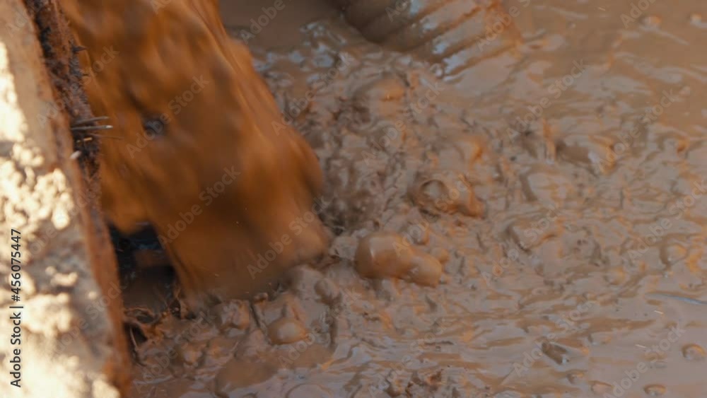 Dirty water pouring from the pipe. A jet of slurry of mud and ...