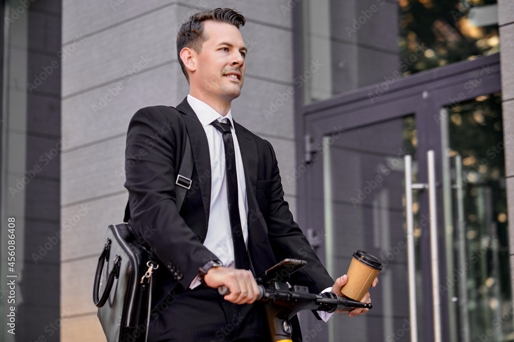 Handsome young office worker moving fast along wall of modern ...