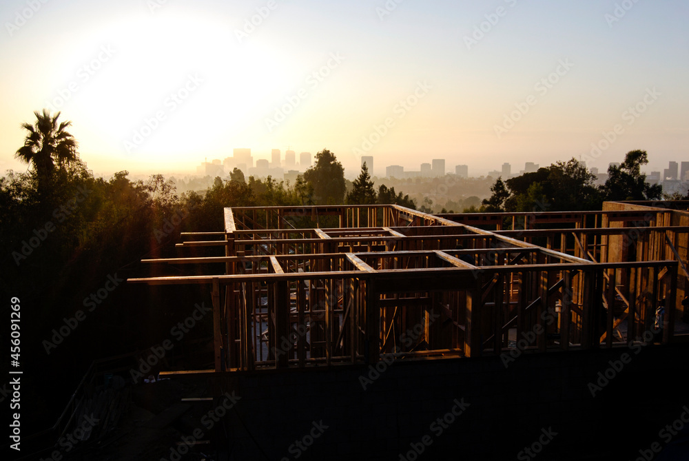 First sunlight over a construction site with structural wood framing ...