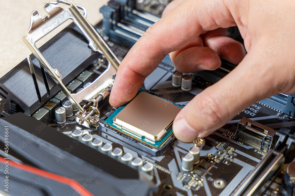 Installing a blank central processor on a motherboard. The blank CPU is ...