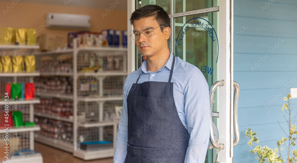 Young male owner expresses his warm welcome with smile to customer for ...