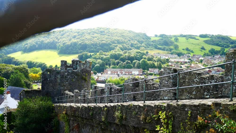 Looking down Conwy castle rampart stone wall lush Welsh mountain valley ...