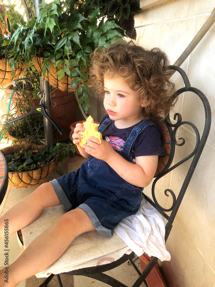 Cute Girl Sitting On Seat Eating Cake Stock Photo | Adobe Stock