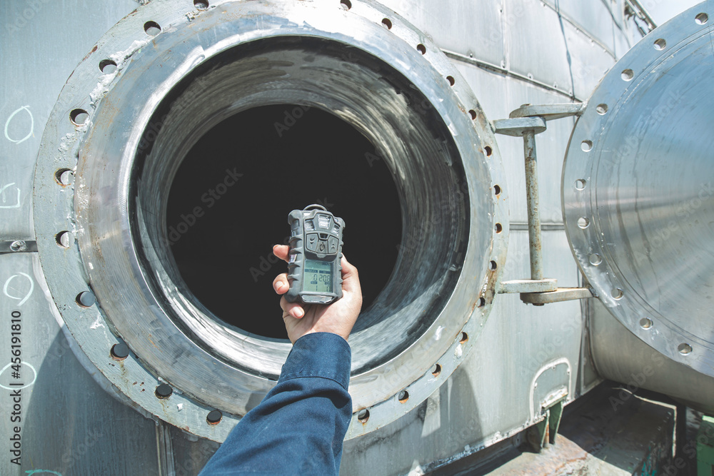 Worker hand holding gas detector inspection safety gas testing at front ...