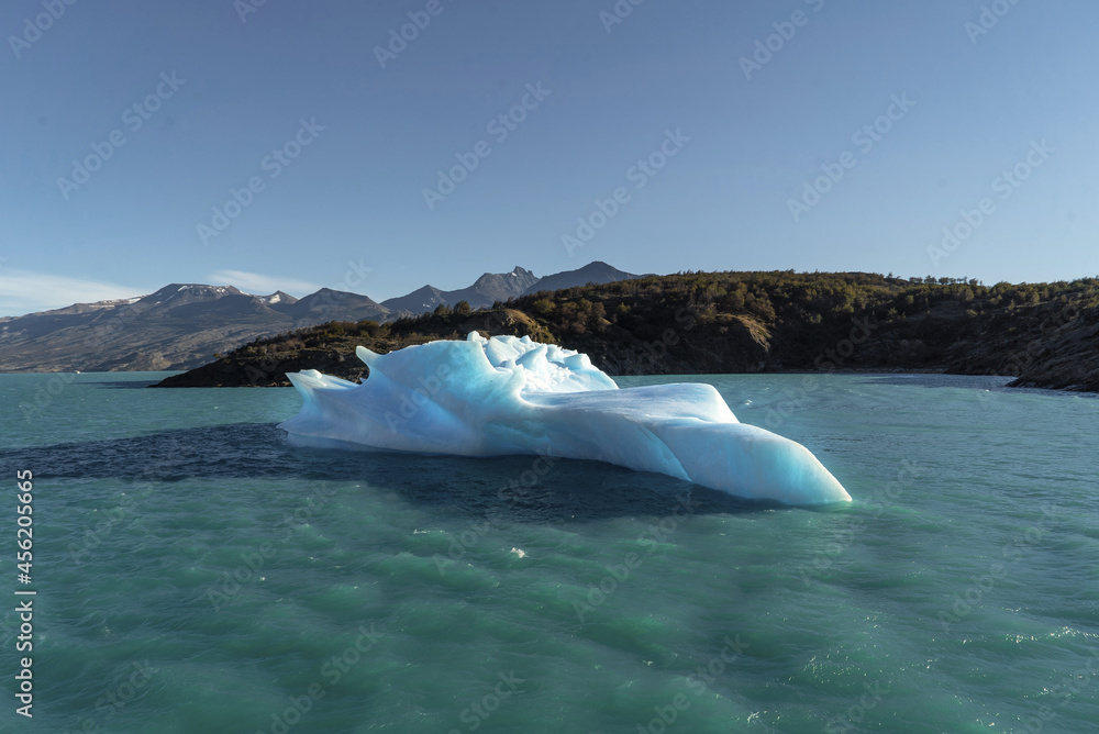 huge block of ice, called an iceberg, floating adrift through the water ...