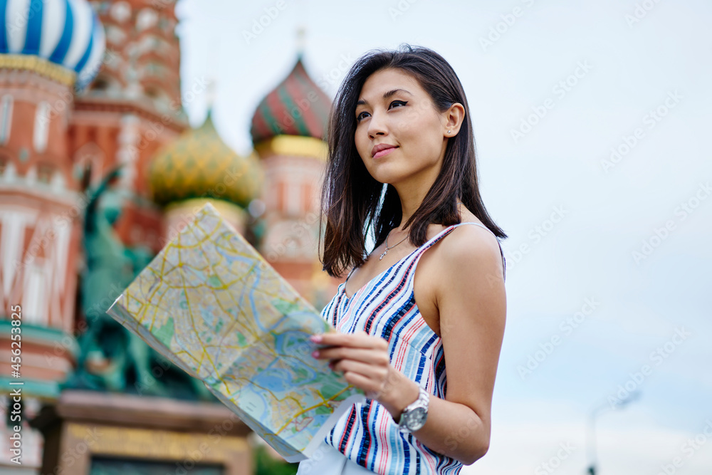 Contemplative Asian tourist with travel map thinking about route ...