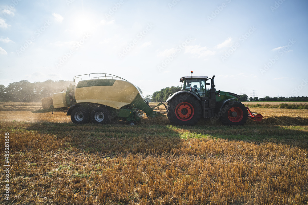 Foto de Strohernte - Traktor mit moderner Hochdruckpresse beim Pressen ... Foto de Strohernte - Traktor mit moderner Hochdruckpresse beim Pressen ...