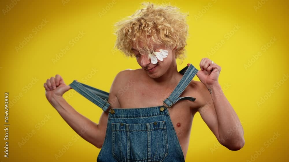 Positive happy queer man moving overalls suspenders in slow motion ...
