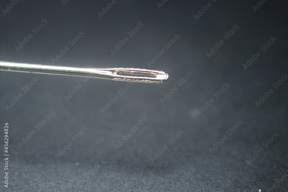 Small needle with empty eyelet, isolated over the black background ...