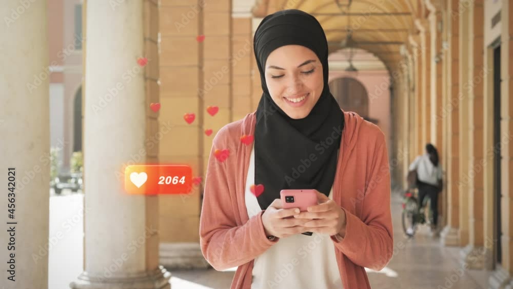 Muslim arab girl walking using smart phone mobile sending likes,heart ...
