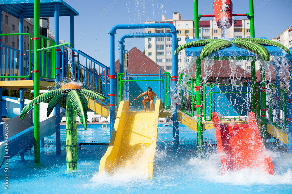 Child in water entertainment center. Happy little girl rides water ...