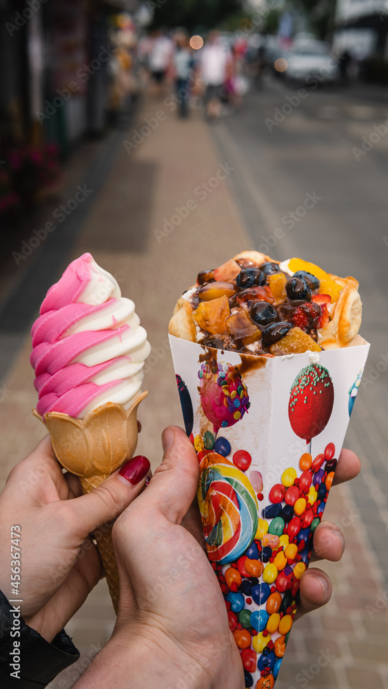 Hong Kong style egg waffles in female hand. Girl in denim jacket hold ...