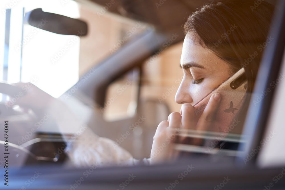Unsafe driving. Young multiracial woman talking on the phone while ...