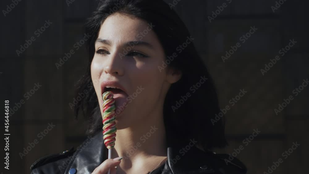 Portrait happy young brunette young woman in trendy stylish look wearing black leather jacket ...