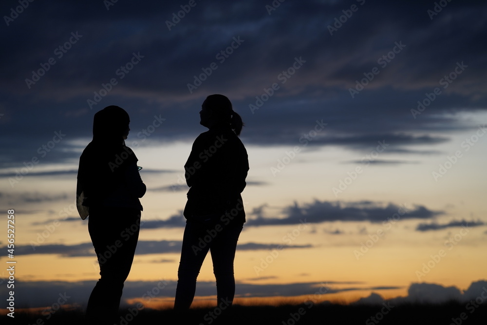 silhouettes of two people talking to each other Stock Photo | Adobe Stock