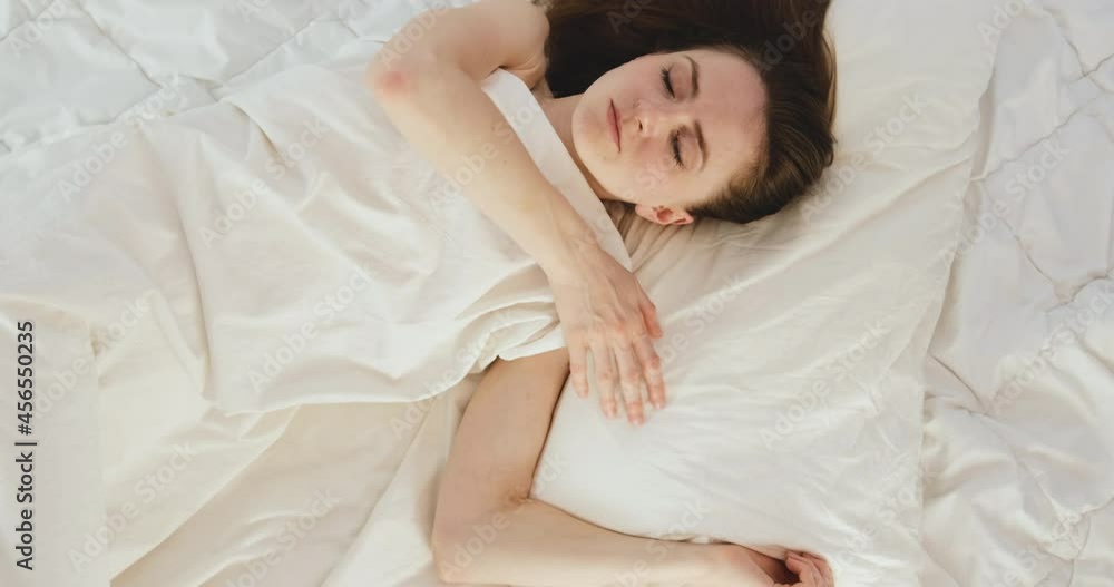 Disturbed annoyed young woman toss and turns lying awake in bed. Top ...