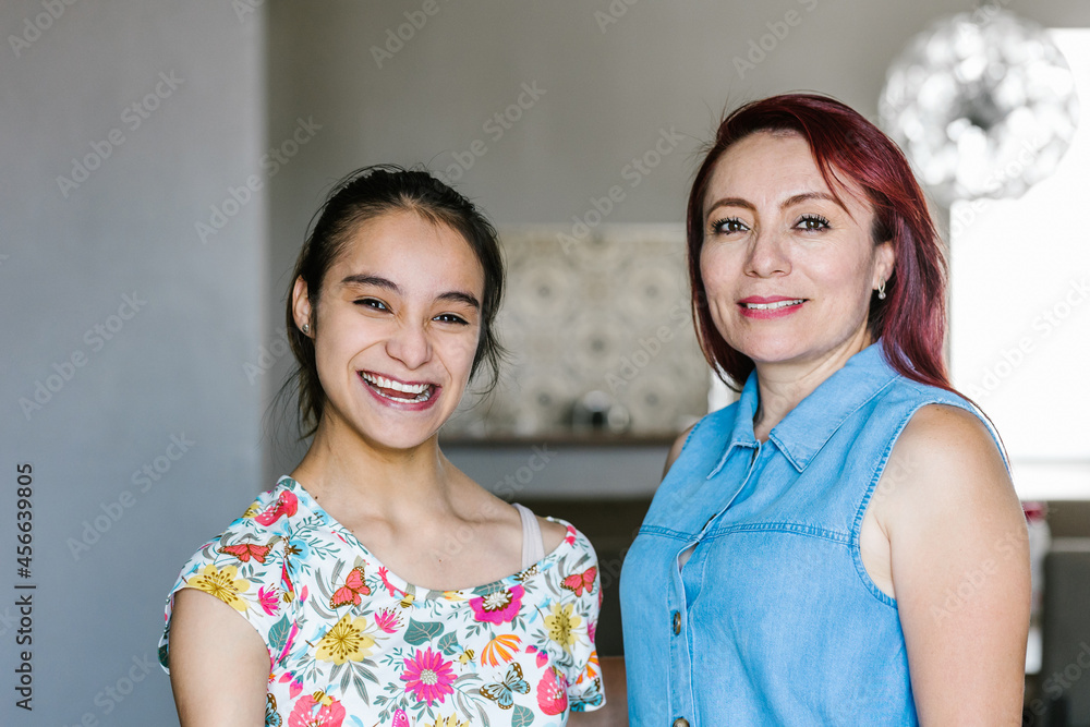 Hispanic teenage girl with cerebral palsy and her mother at home in ...