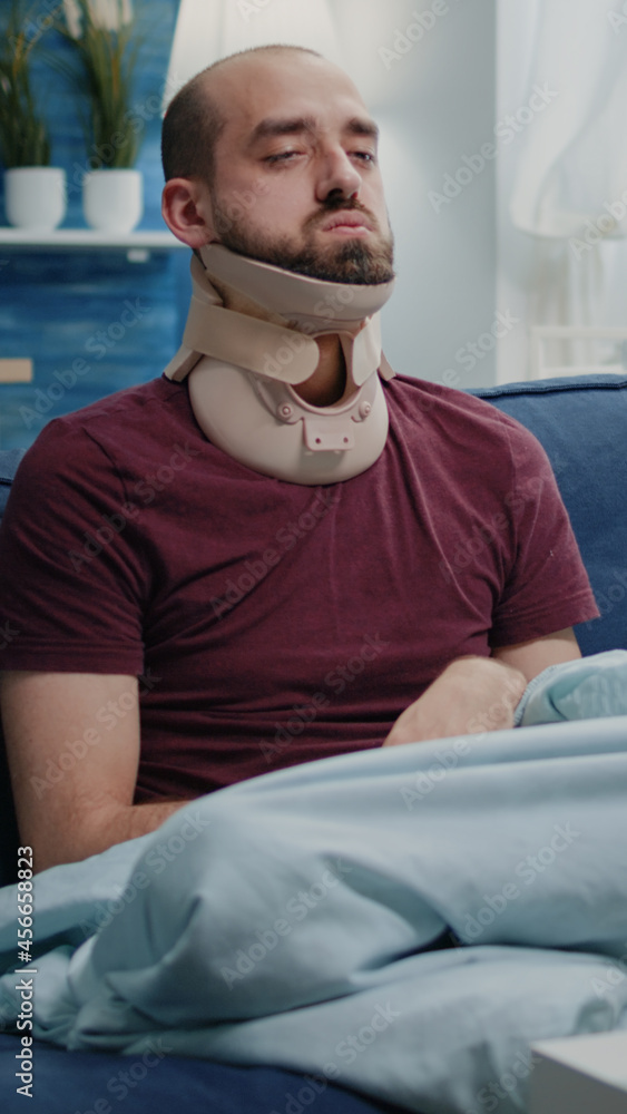 Injured man wearing cervical neck collar against muscle pain. Sick ...