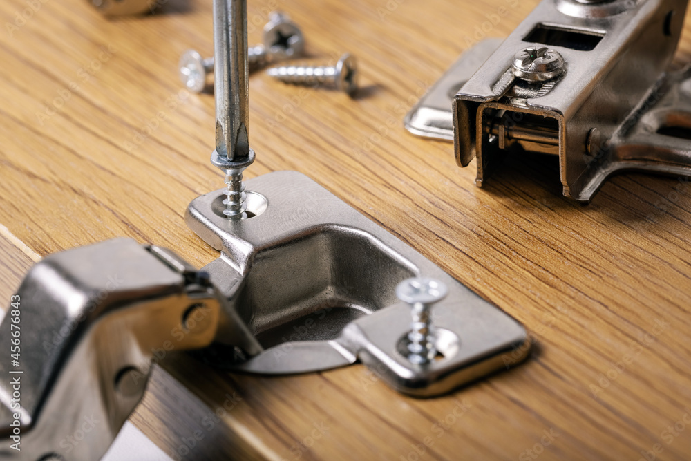Foto de furniture assembly - screwing the hinge on laminated mdf board ...