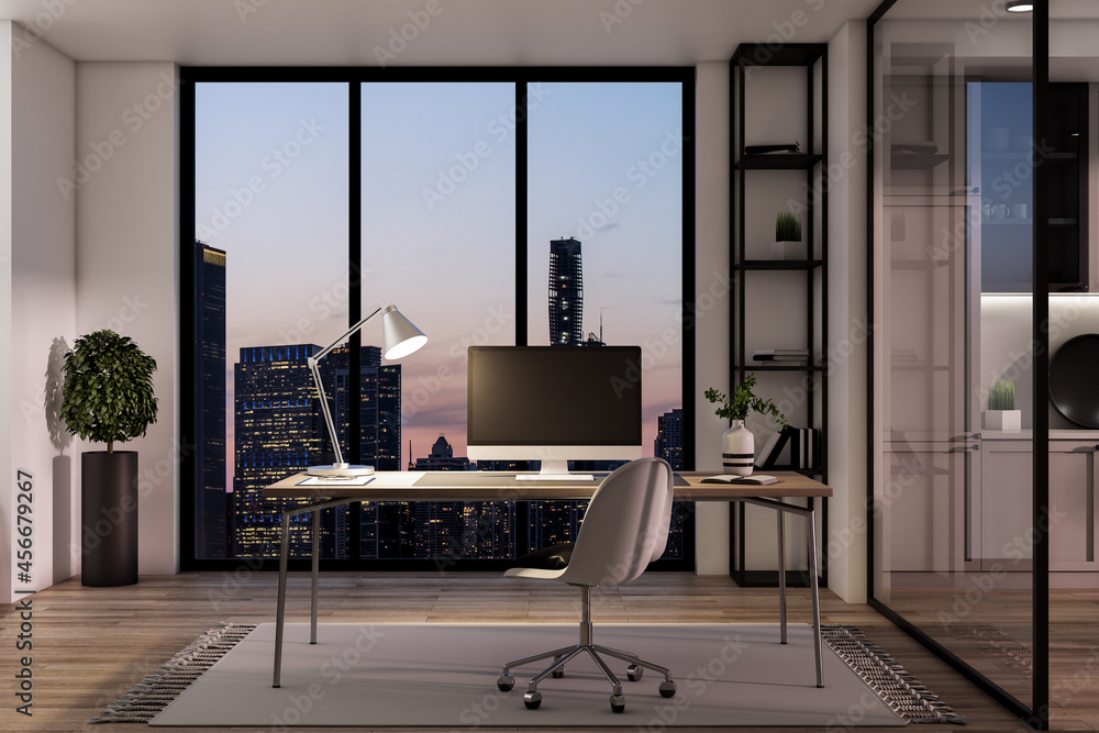 Empty computer monitor in creative modern nighttime office studio ...