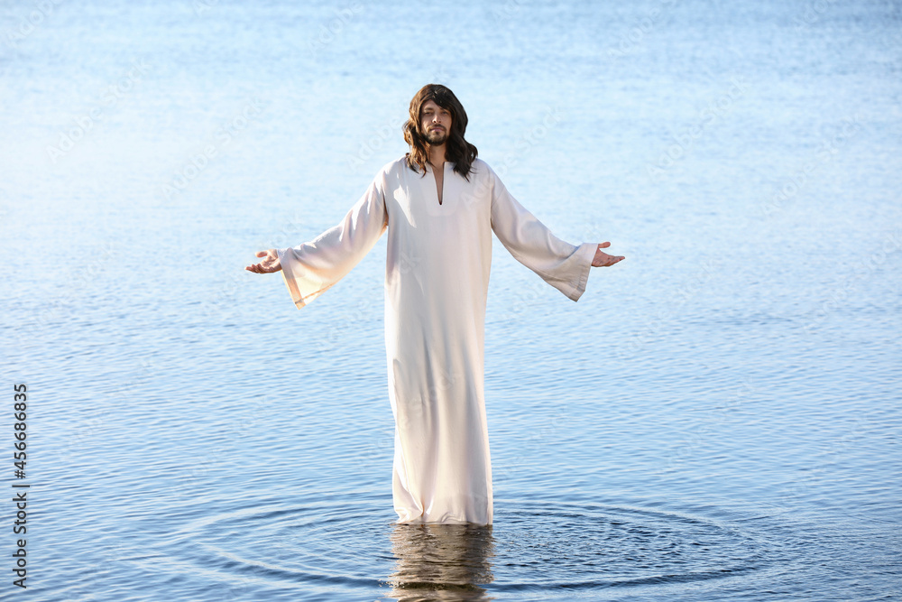 Jesus Christ in water lit by morning sun Stock Photo | Adobe Stock