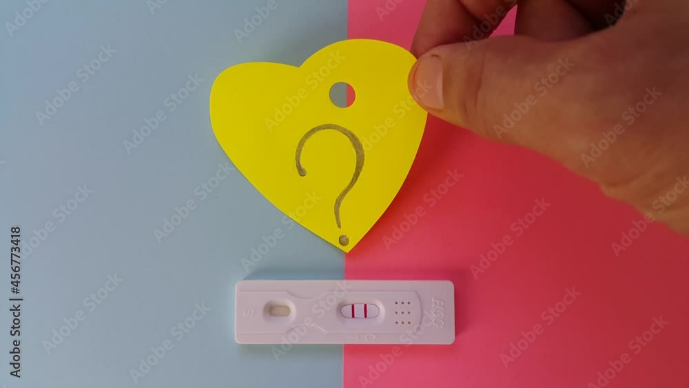 The hCG test lies on a blue and pink background and shows two red lines ...