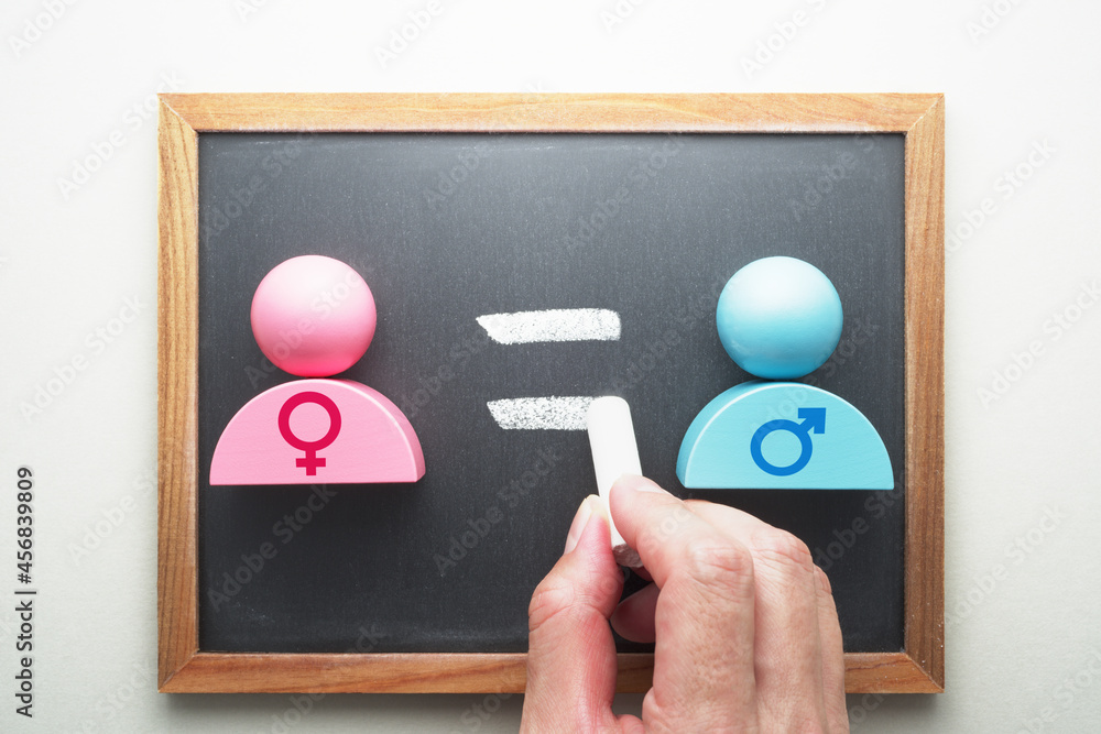 Gender equality. Female and male symbols. Hand writing equal sign on ...