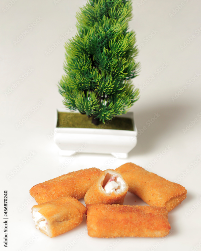 Fried spring rolls isolated on a bright background. This typical ...