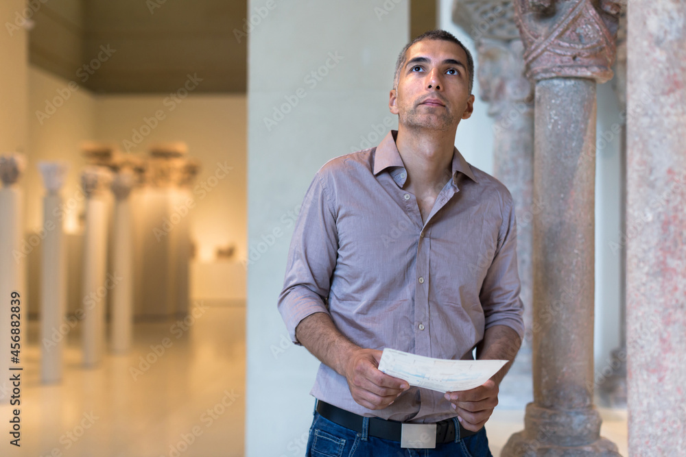 Adult male is visiting at the exposition with brochure in the ...