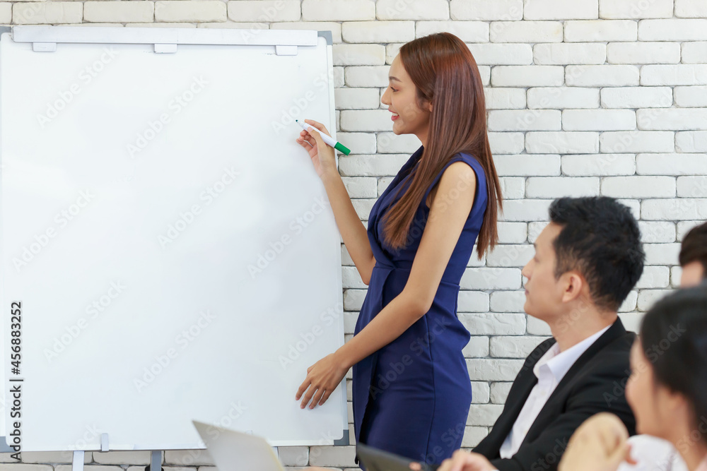 Young attractive Asian business women standing presenting project to ...
