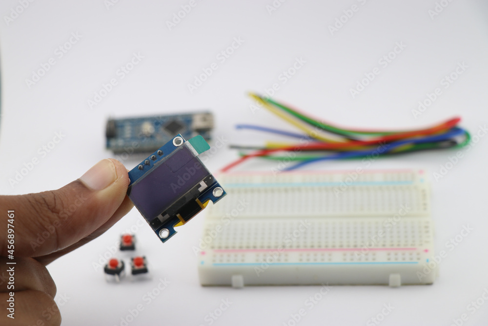 Young inventor holding OLED display in hand, Arduino display module ...