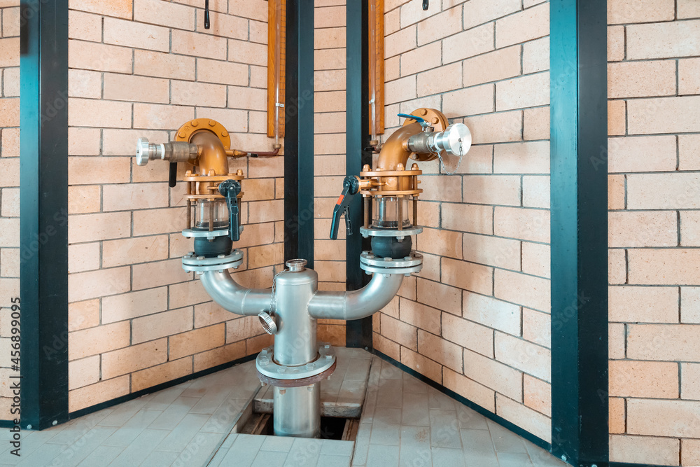 Foto de An industrial pipe in the basement near a brick wall with a ...