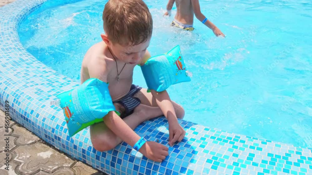 Young boy kid child is splashing in swimming pool and having fun ...