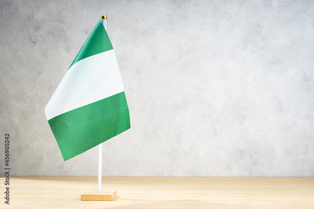 Nigeria table flag on white textured wall. Copy space for text, designs ...