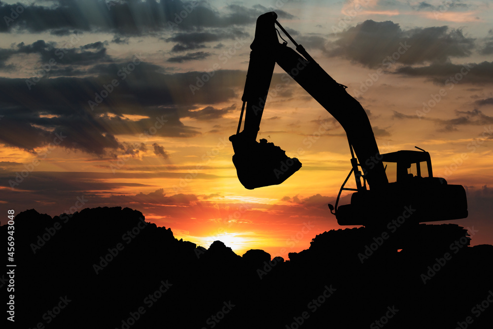 Excavators silhouette are digging the soil in the construction site ...