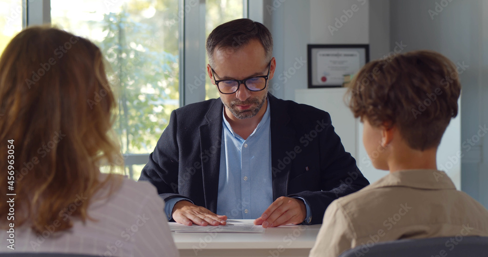Back view of mother and son having interview with school headmaster ...