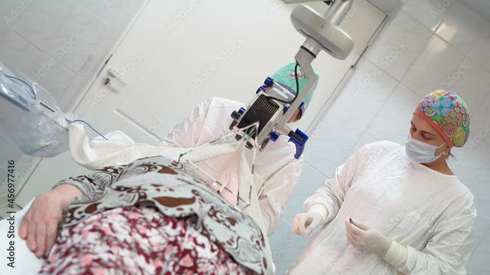 Two Female Surgeons Perform Eye Surgery with a Microscope and Medical ...