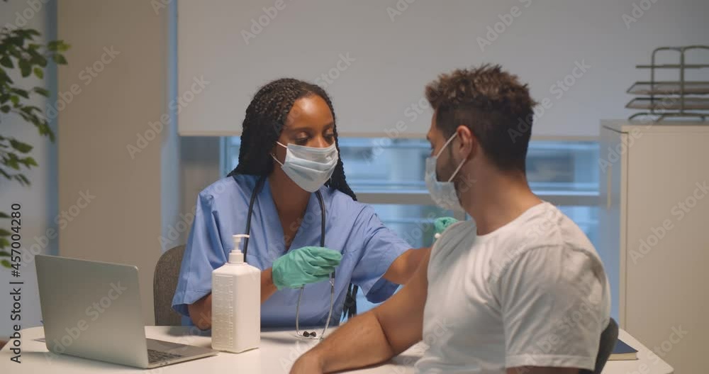 Professional doctor or nurse giving covid-19 vaccine injection to young ...