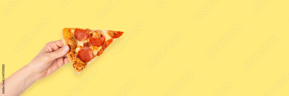Slice of pepperoni pizza in hand isolated on yellow. Top view on ...