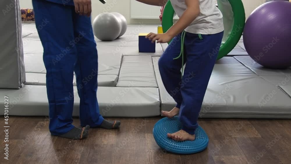 Kid girl with therapist do exercise on touch pad foot massager during ...