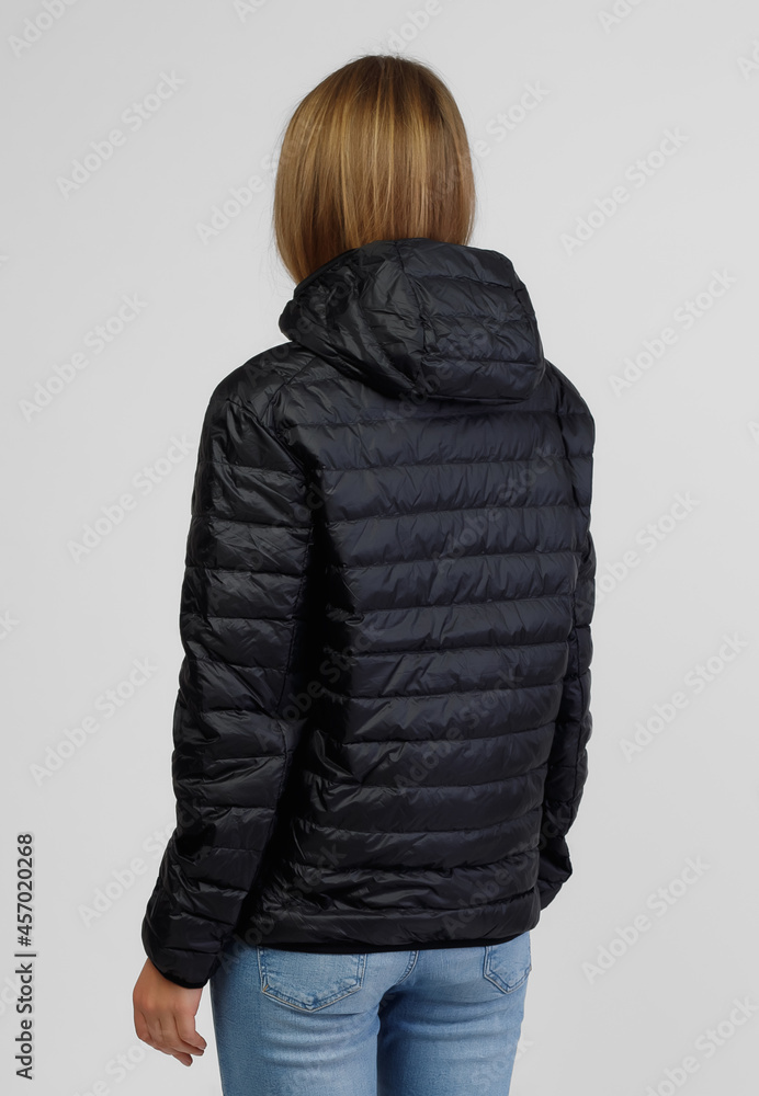 Young female model posing in black down jacket isolated on white ...