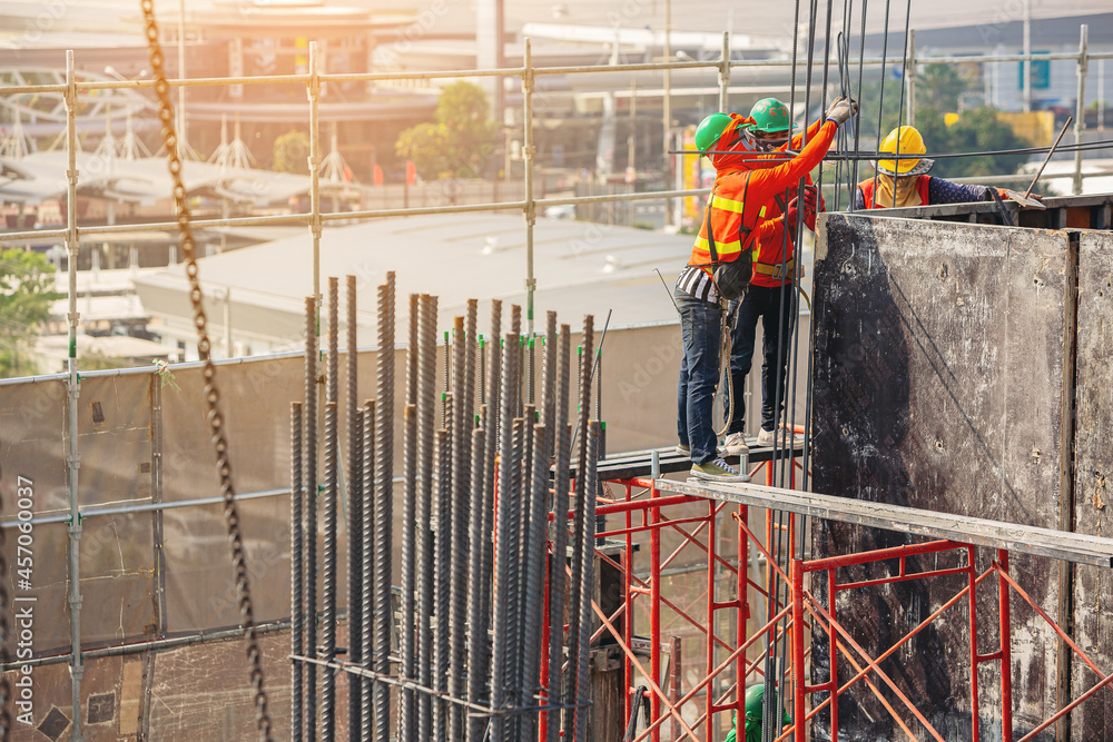 Construction workers in safety uniform install reinforced steel ...
